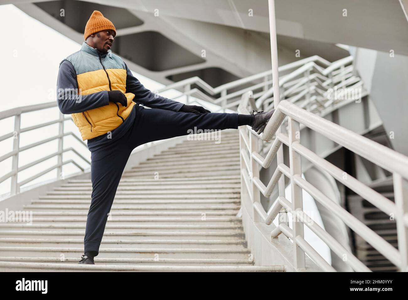 Young contemporary sportsman of African ethnicity standing on staircase ...