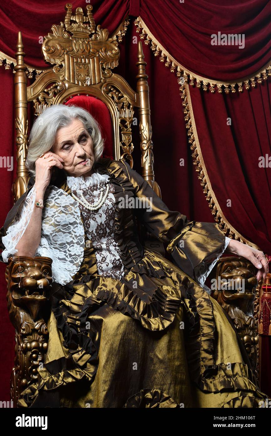 Portrait of sad beautiful senior queen on throne Stock Photo - Alamy