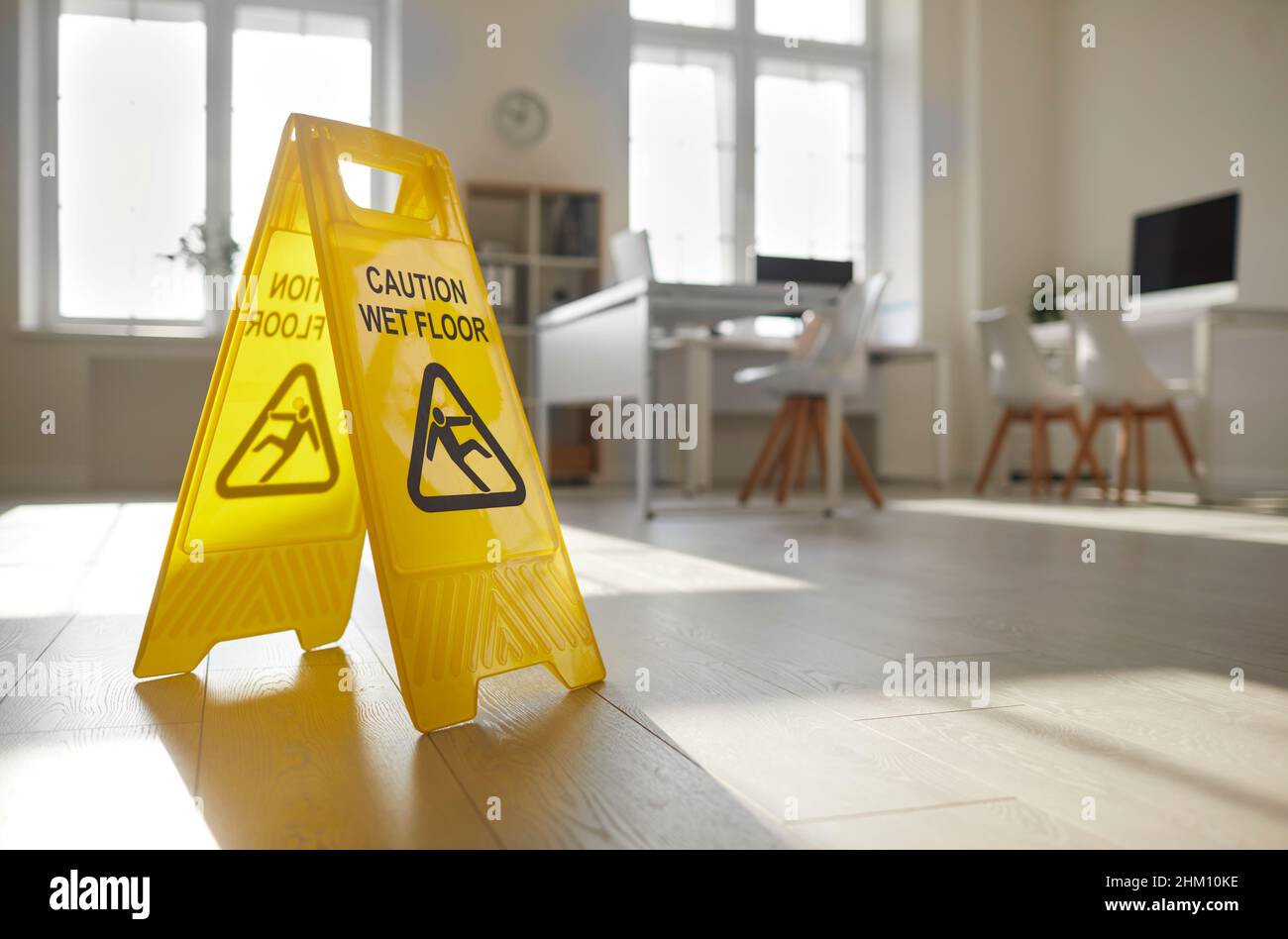 Yellow 'Caution Wet Floor' sign placed in clean empty office by ...