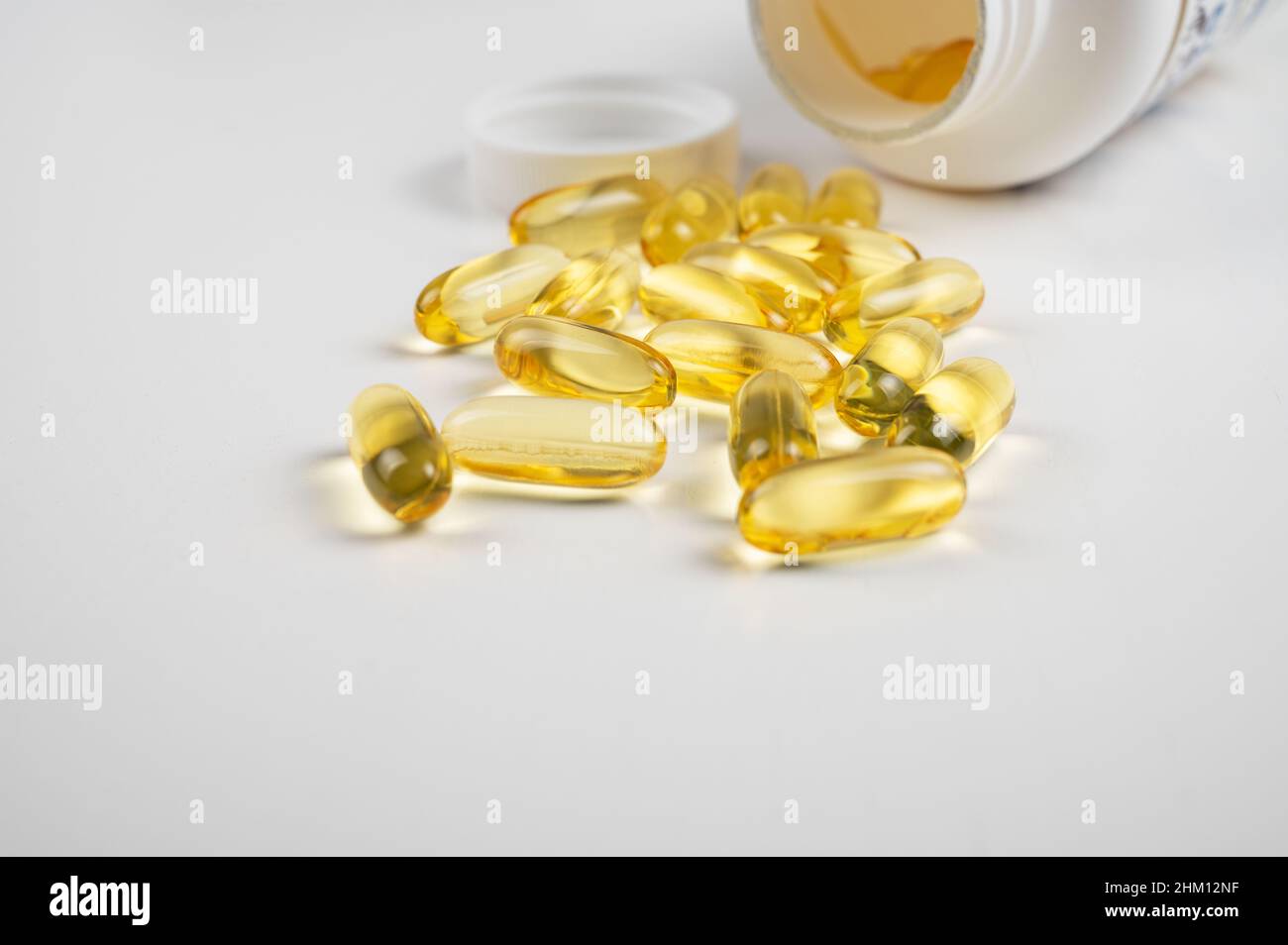 Gold fish oil isolated on white background. Pile of fish oil with Omega ...