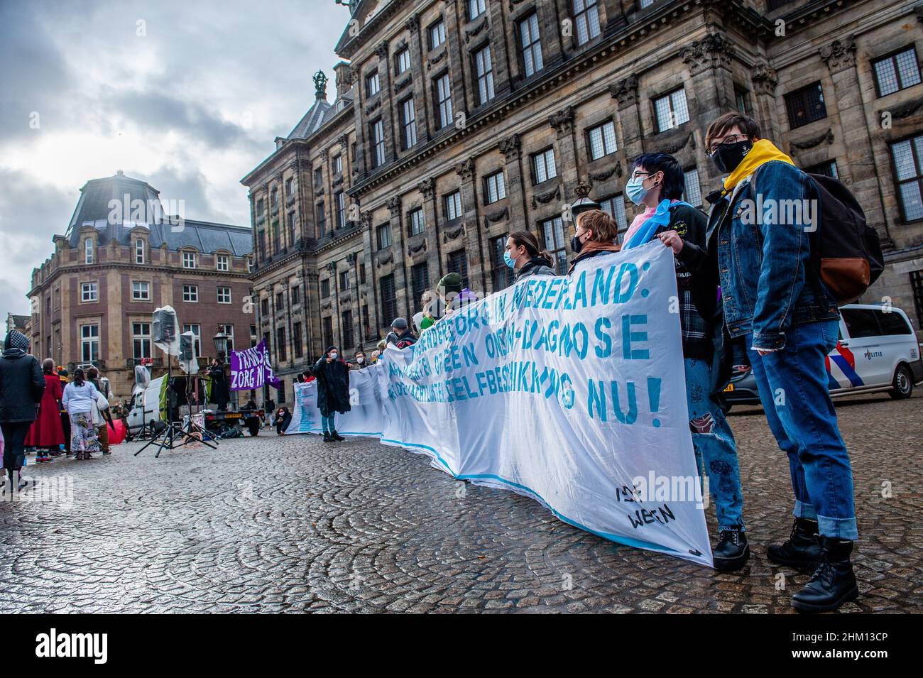 A group of protesters hold a big banner that marks how long is the ...