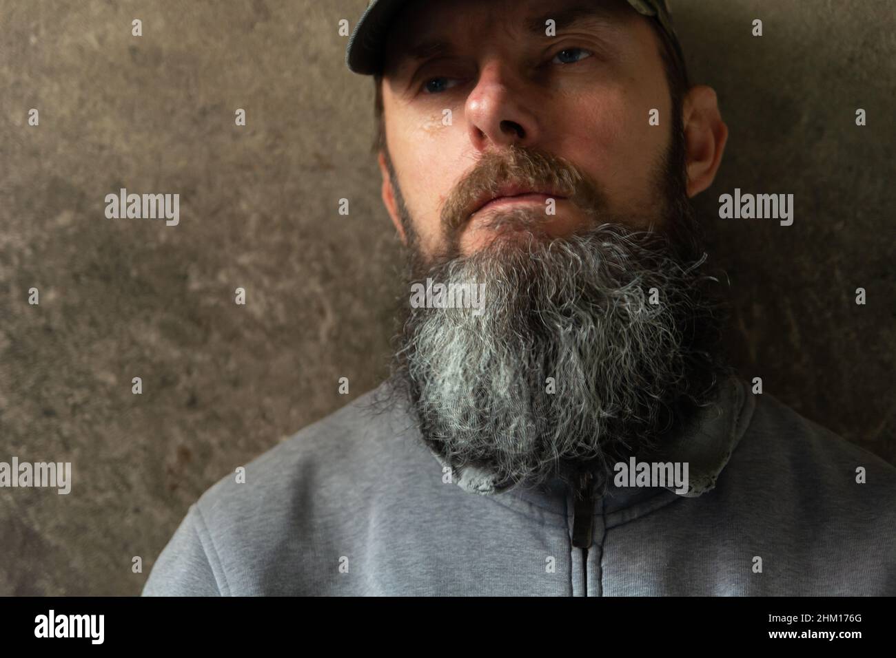 Bearded man in a baseball cap on the dark wall background Stock Photo ...