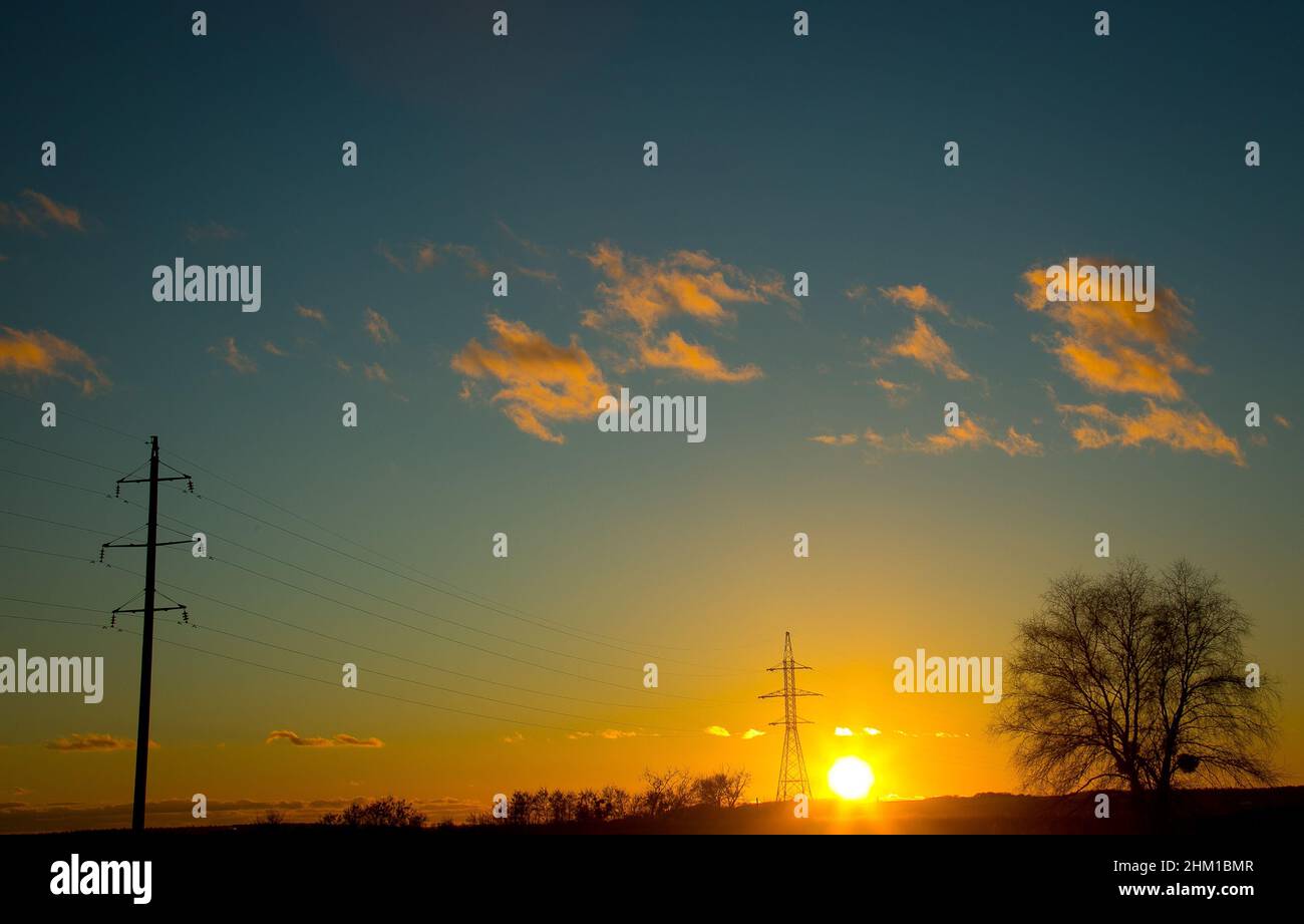 Power transmission towers or electricity pylons with golden sky and ...