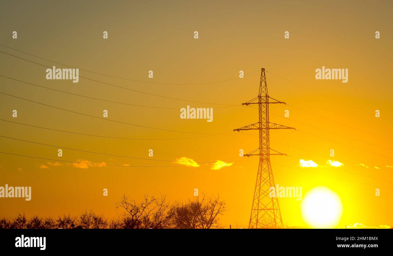 Power transmission towers or electricity pylons with golden sky and ...