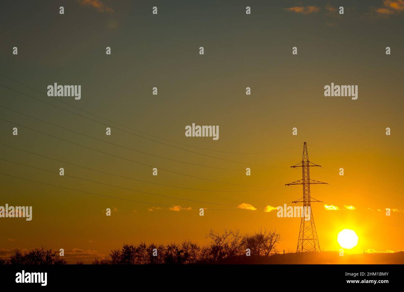 Power transmission towers or electricity pylons with golden sky and ...