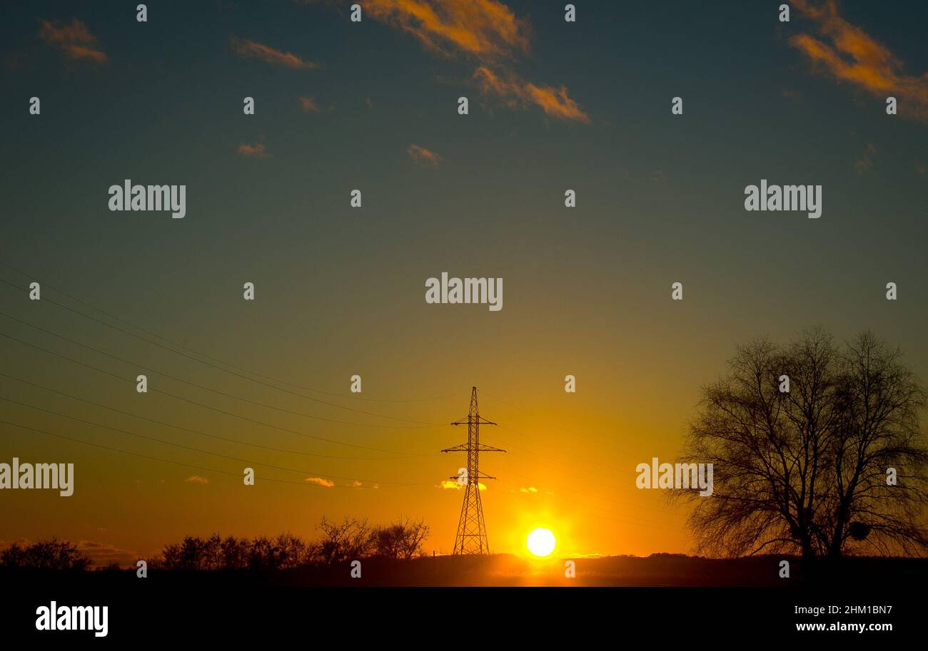 Power transmission towers or electricity pylons with golden sky and ...
