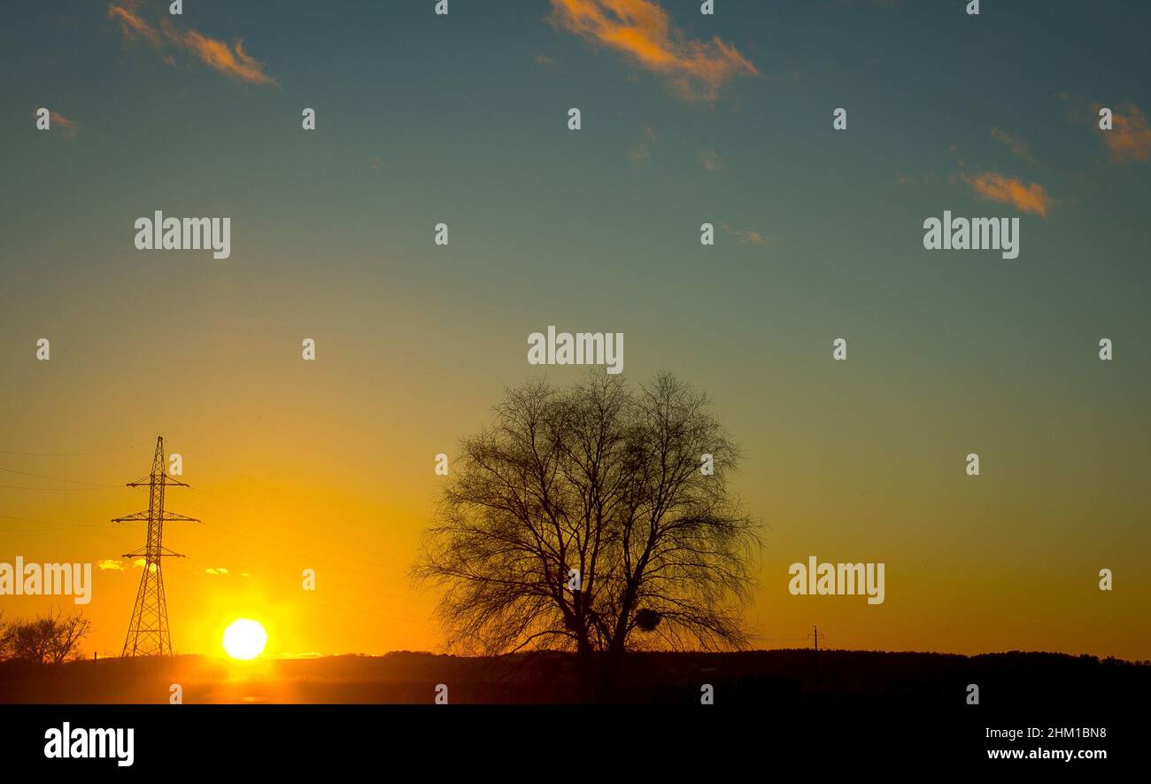 Power transmission towers or electricity pylons with golden sky and ...