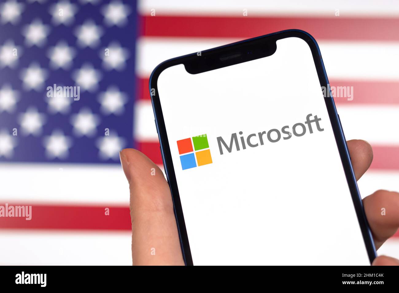 Microsoft American company logo on USA flag background. Hand with ...