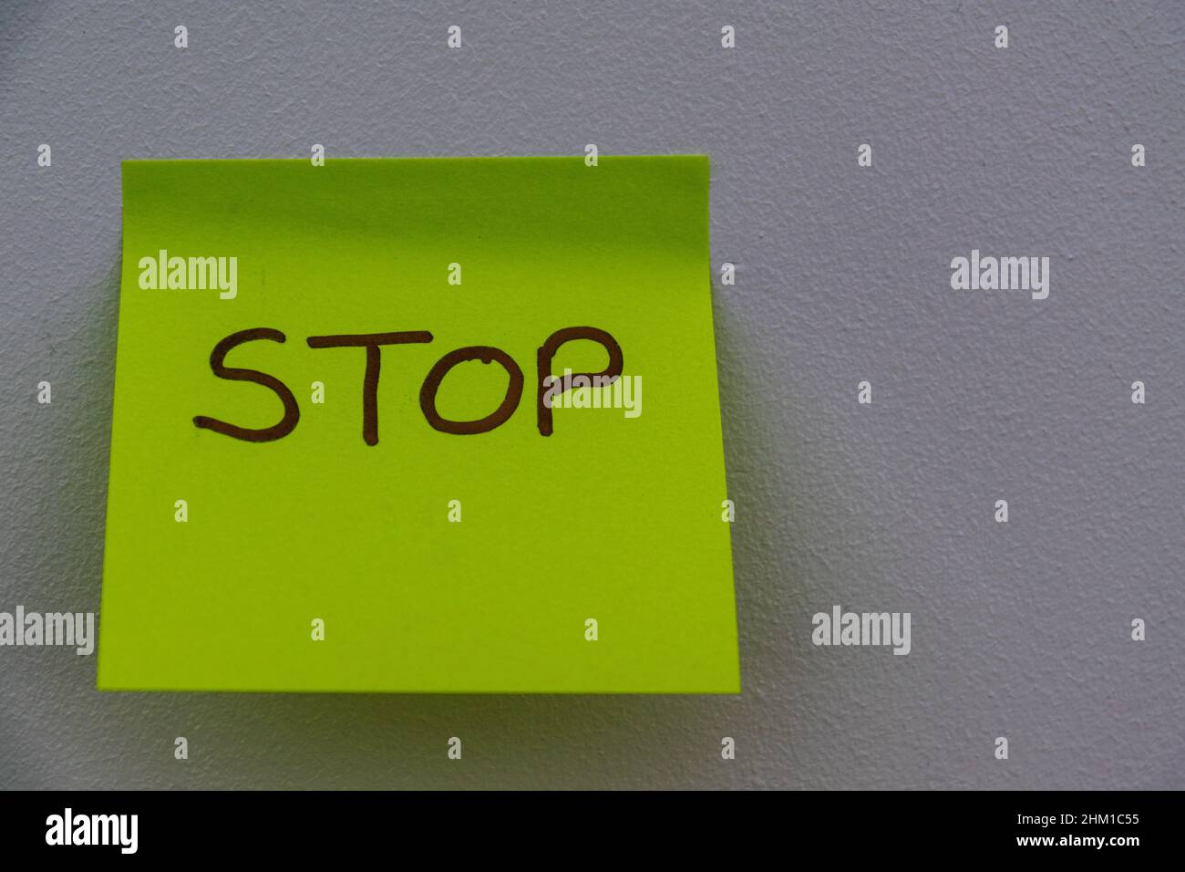 Stop hand wrote on a sticky note, isolated. Danger, safeguard, half ...