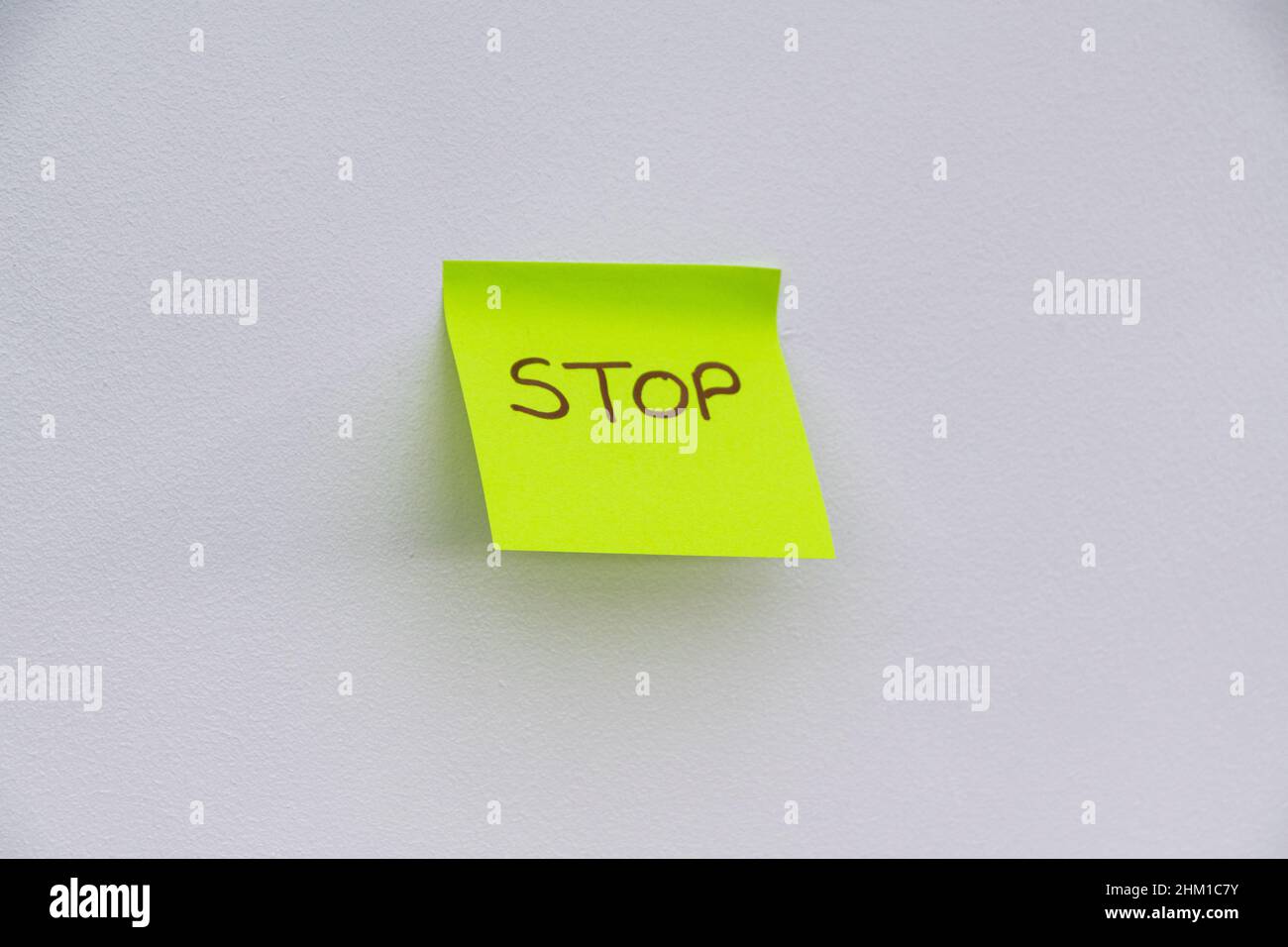 Stop hand wrote on a sticky note, isolated. Danger, safeguard, half ...