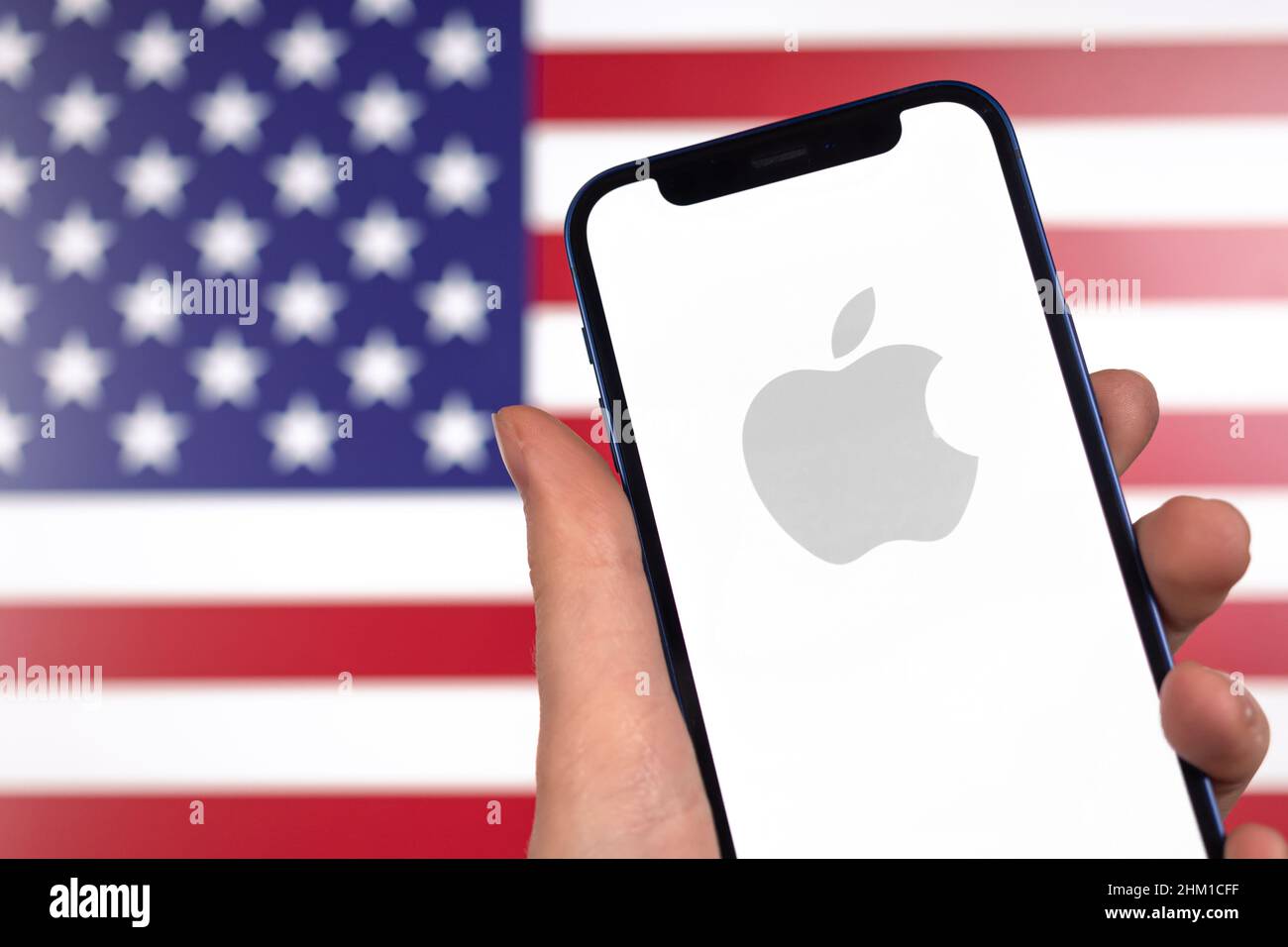 Apple American company logo on USA flag background. Hand with mobile ...