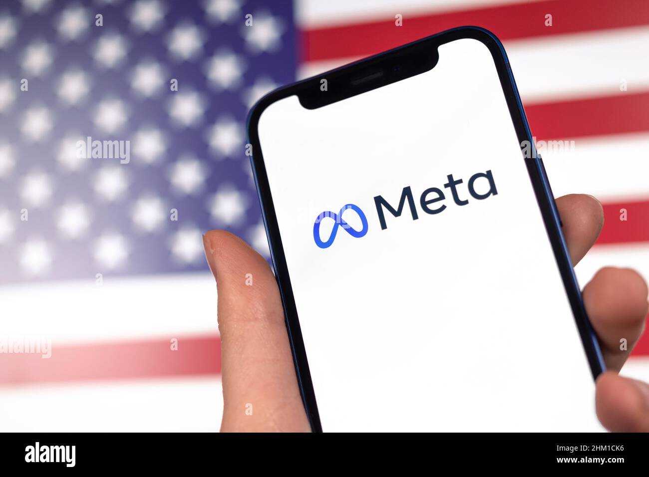 Meta logo on USA flag background. American company. Hand with mobile ...