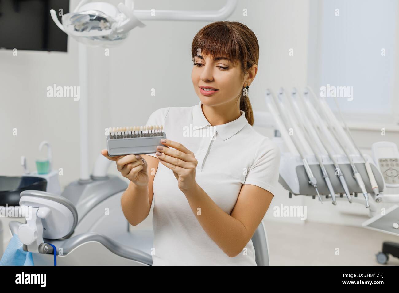 Dentist demonstrate teeth color shades guide for tooth whitening. Close ...