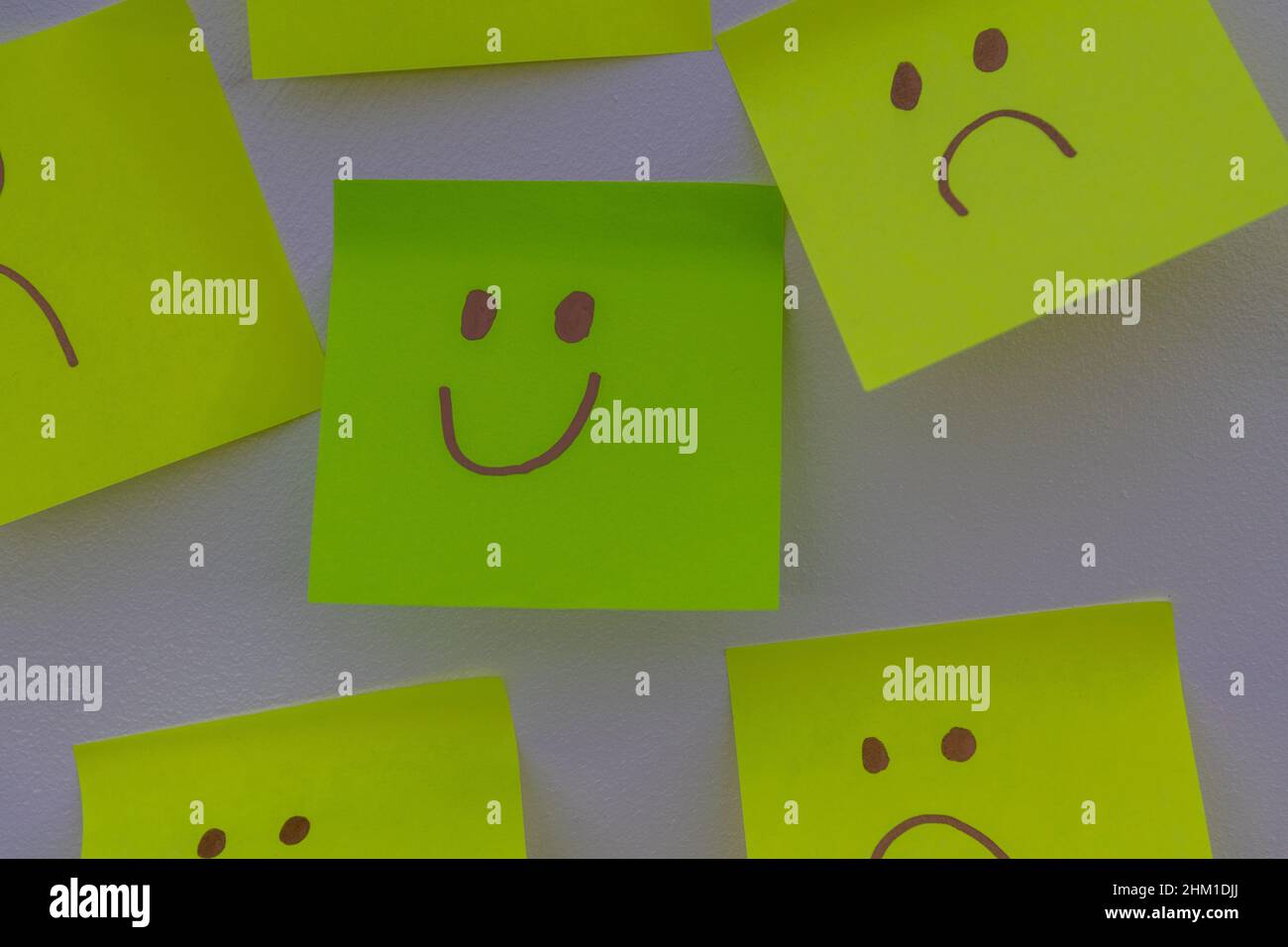 Happy smiling face amongst lots of sad faces. Hiding depression, mental ...