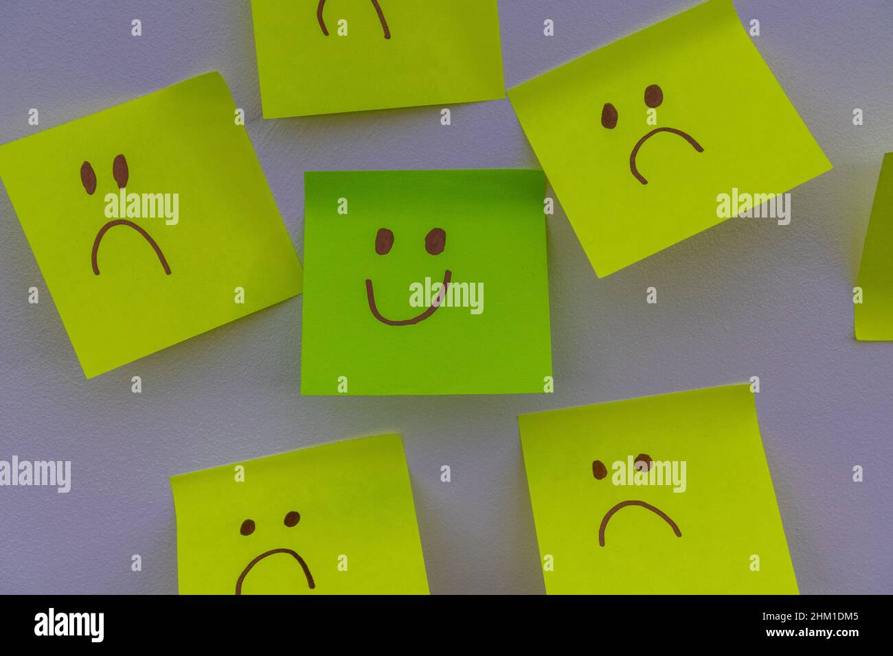 Happy smiling face amongst lots of sad faces. Hiding depression, mental ...