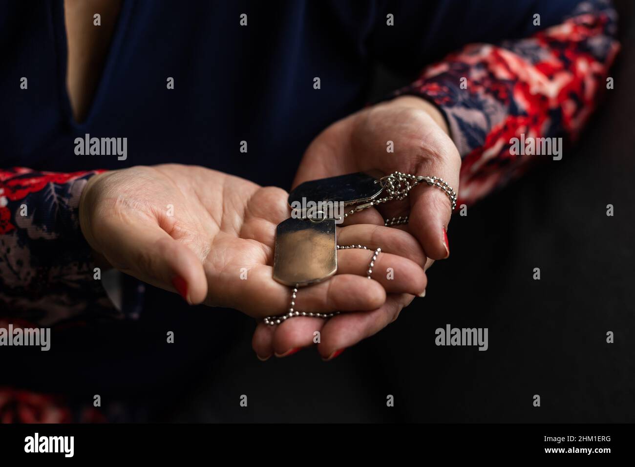 elderly woman holding in hand military token Stock Photo - Alamy