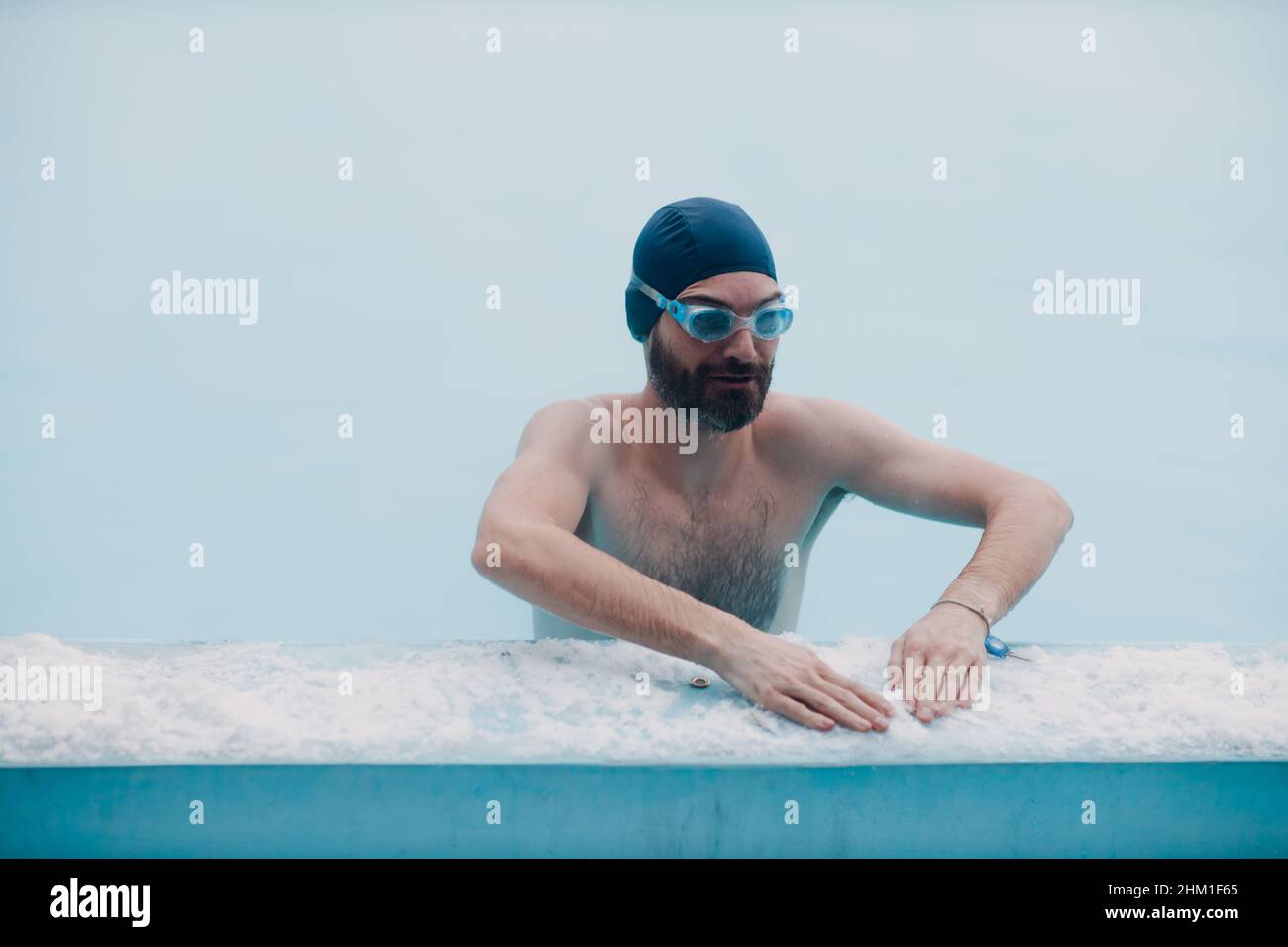 Fit swimmer male training swim in open winter swimming pool with fog ...