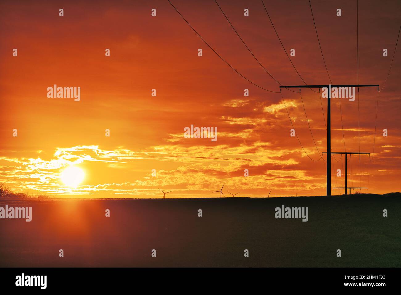 electricity poles in a red sunset with sunrays and clouds Stock Photo ...