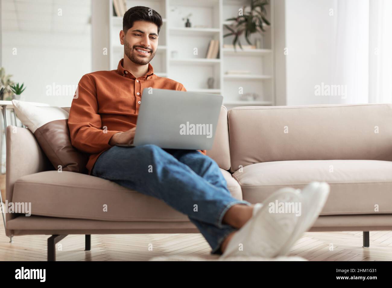 Portrait of smiling Arab man using pc at home Stock Photo - Alamy