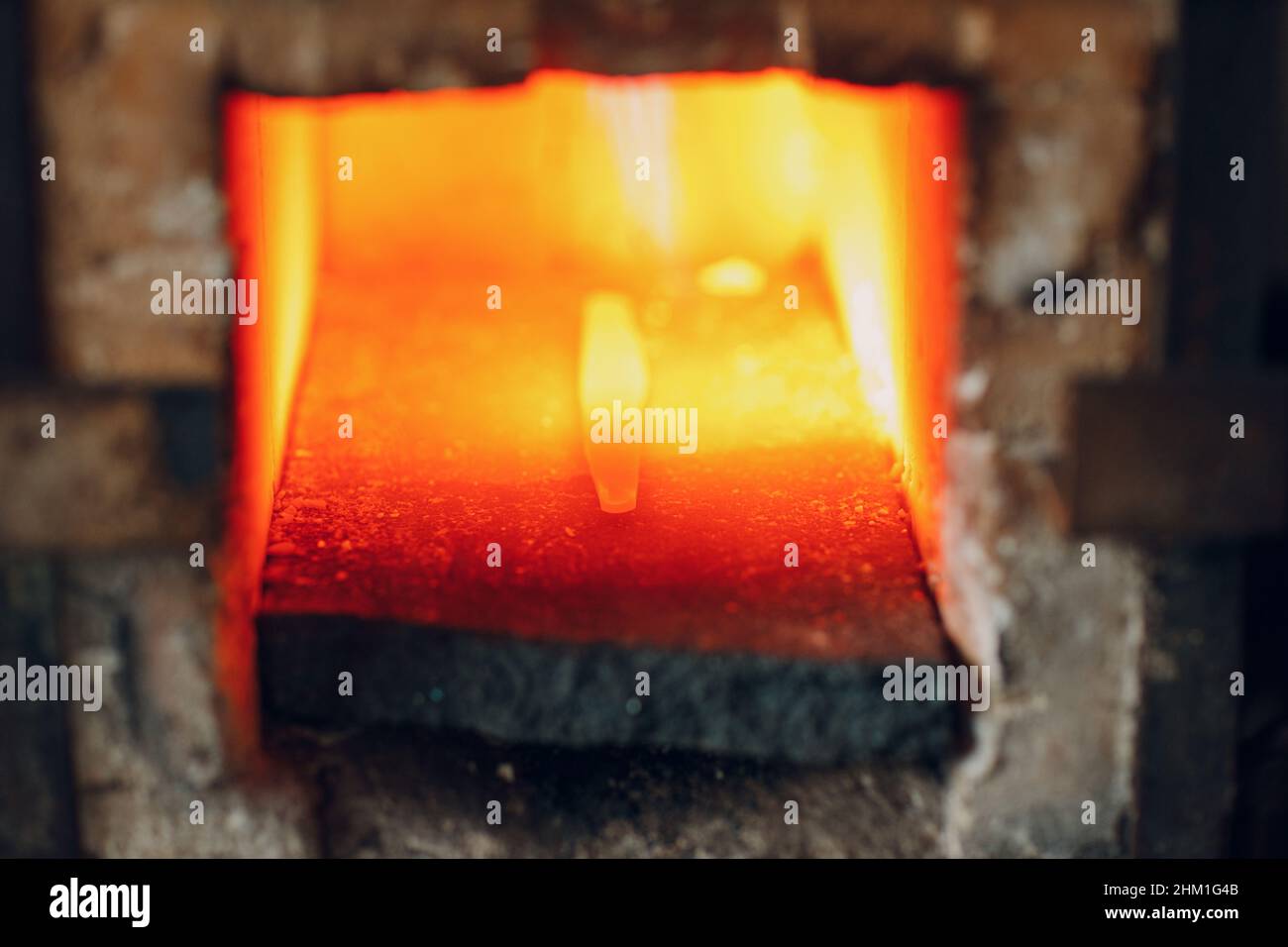 Blacksmith forge oven with hot flame. Smith heating iron piece of steel ...