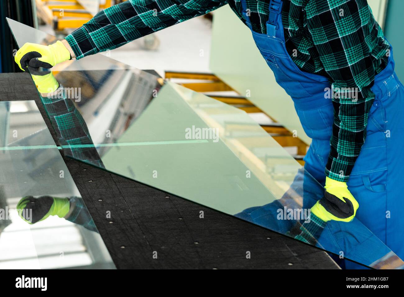 The glazier places a pane of glass on a specialized table, Work in a ...