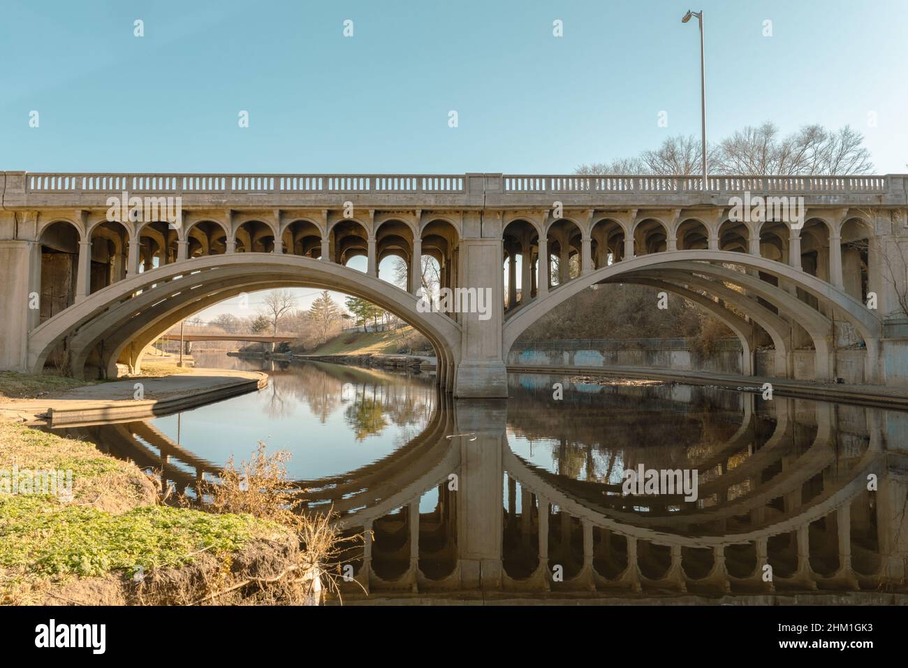 Arched bridge with reflection on a river against a cloudy sky Stock ...