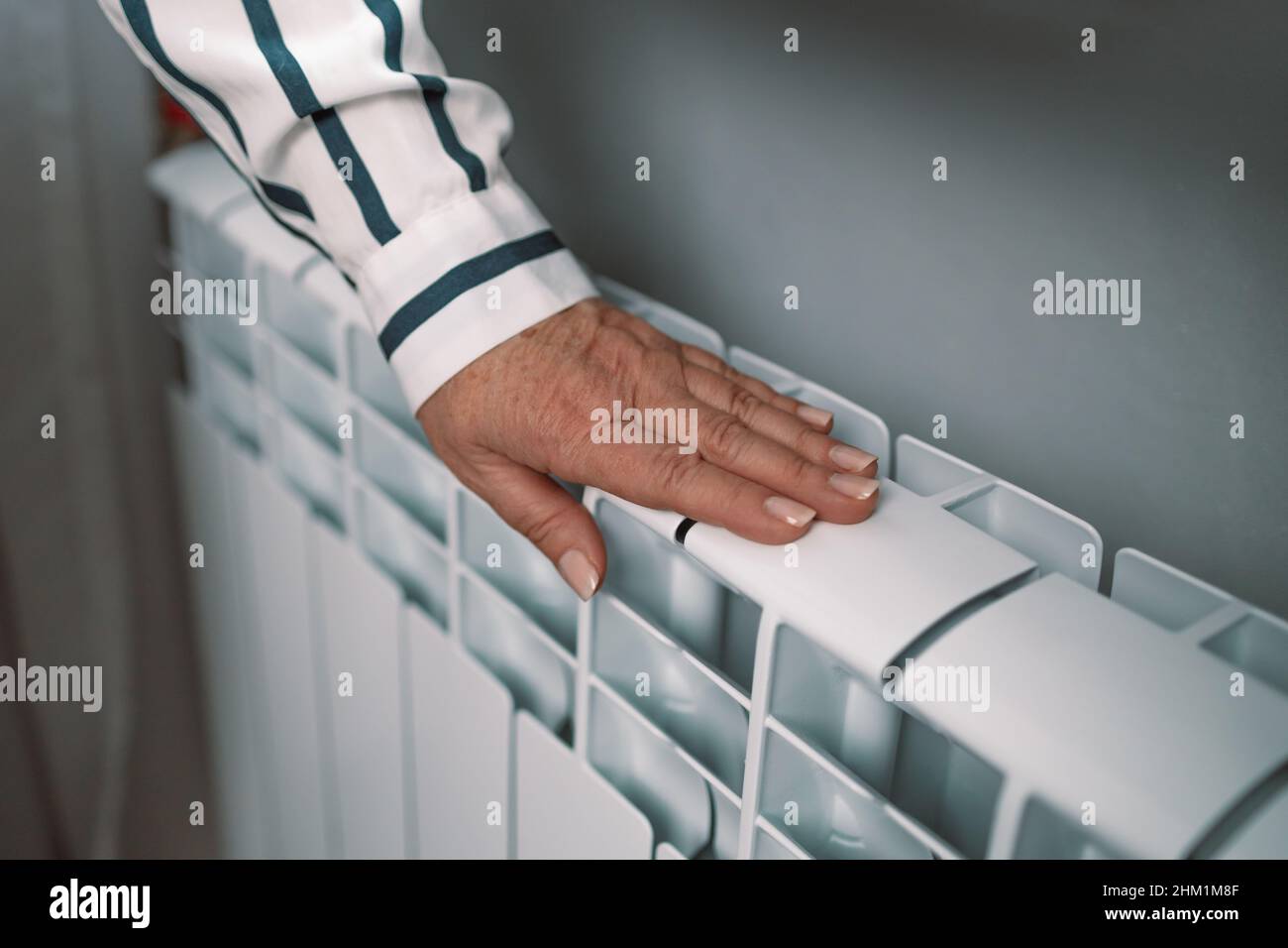 Female touching barely warm battery during heating season. Heating ...