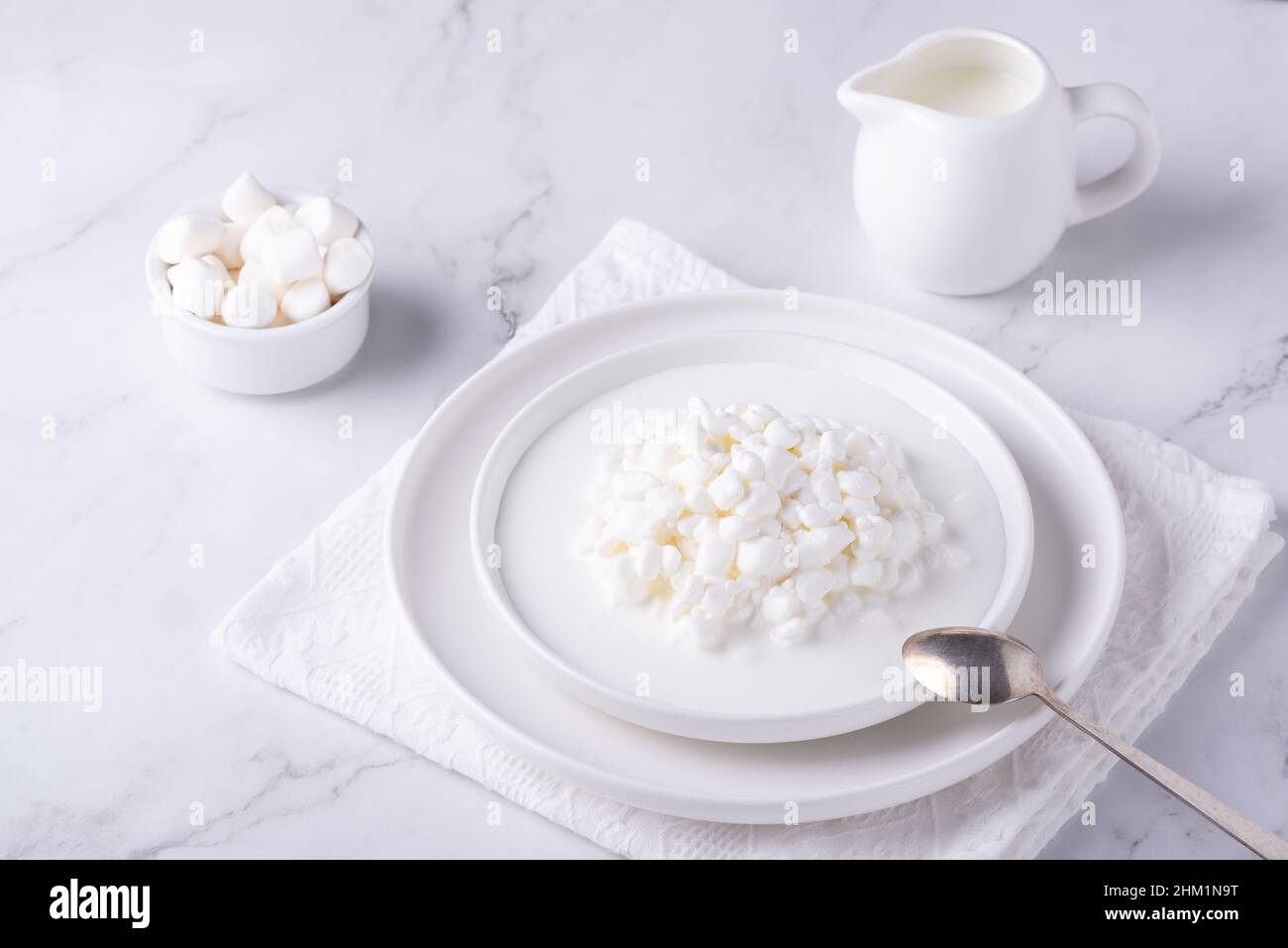 Fresh cottage cheese grain in a white bowl and marshmallows Stock Photo ...