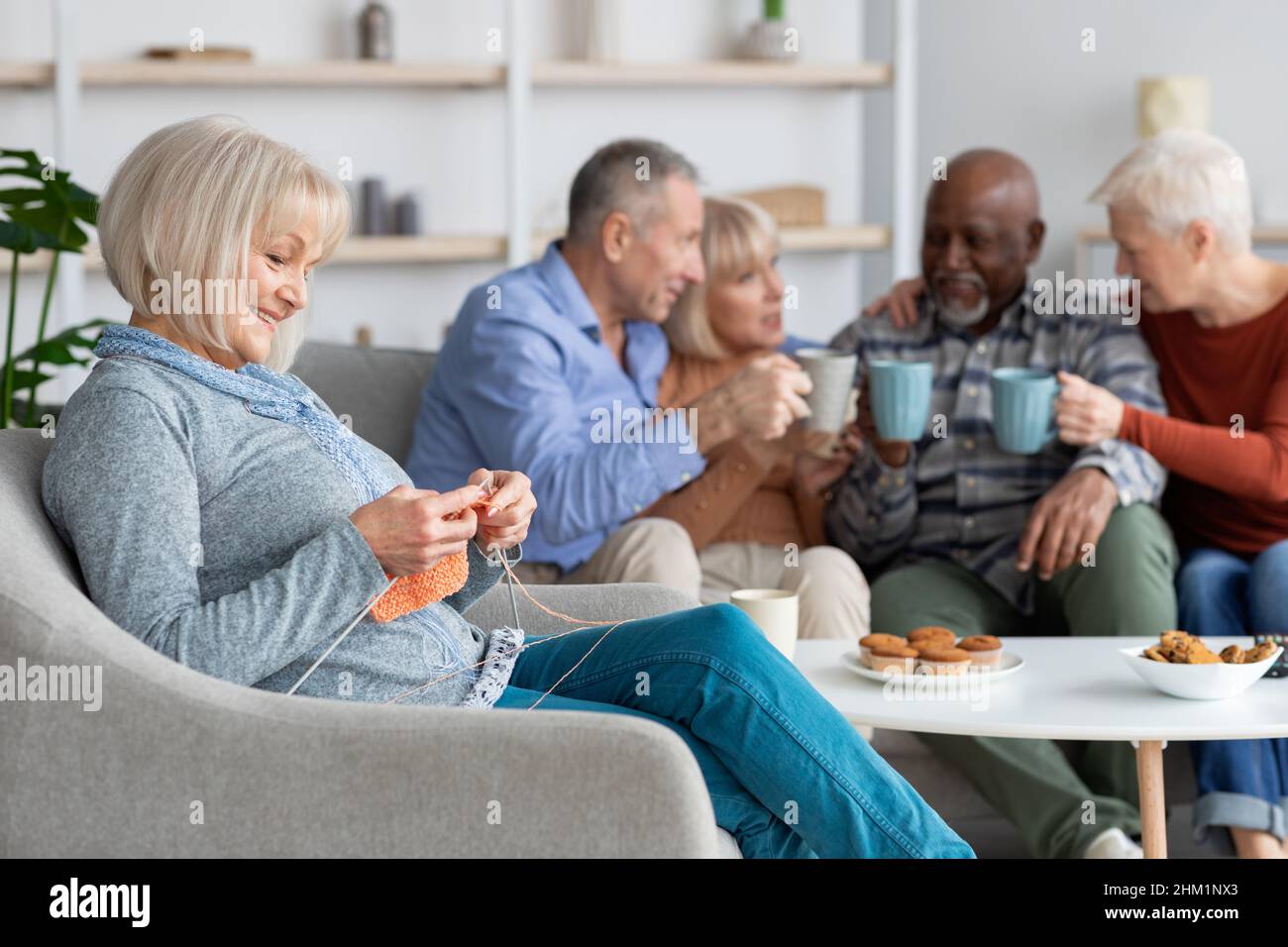 Relaxed senior lady knitting, sitting by her multiracial friends Stock ...