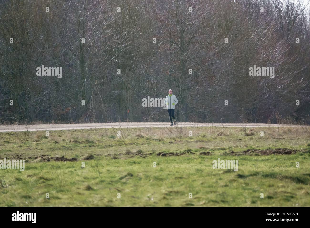 man wearing high visibility socks jogging on an unmade track road Stock ...