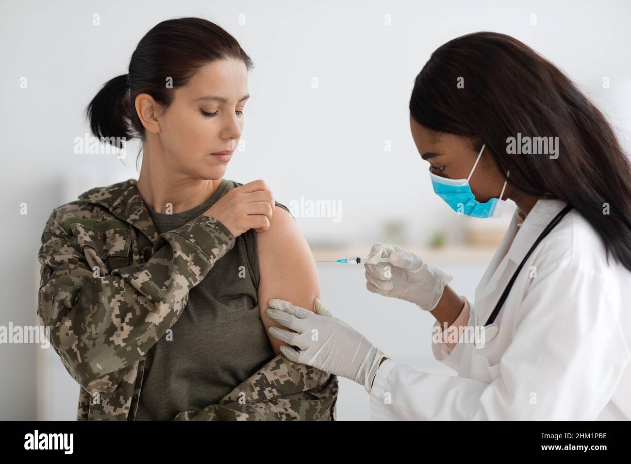 African American Nurse Making Vaccine Injection Shot To Young Soldier ...