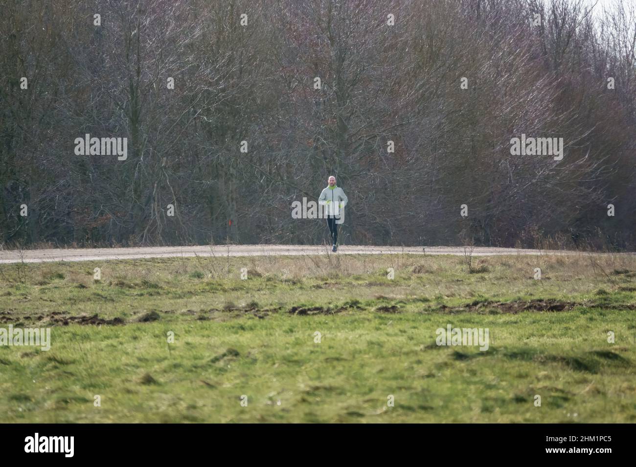 man wearing high visibility socks jogging on an unmade track road Stock ...
