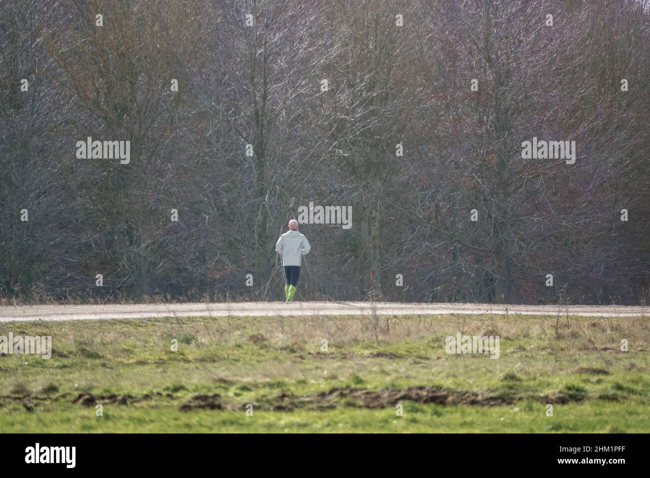 man wearing high visibility socks jogging on an unmade track road Stock ...