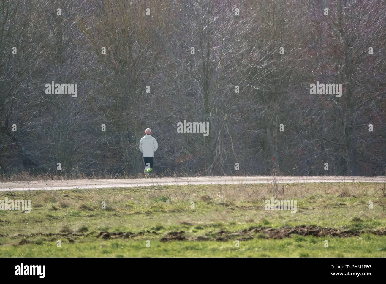 man wearing high visibility socks jogging on an unmade track road Stock ...