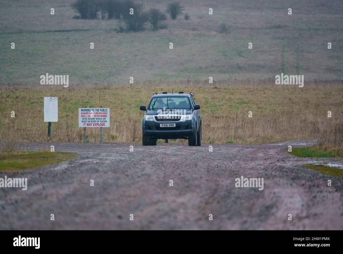 black toyota hilux SUV car driving along an unmade stone track road ...