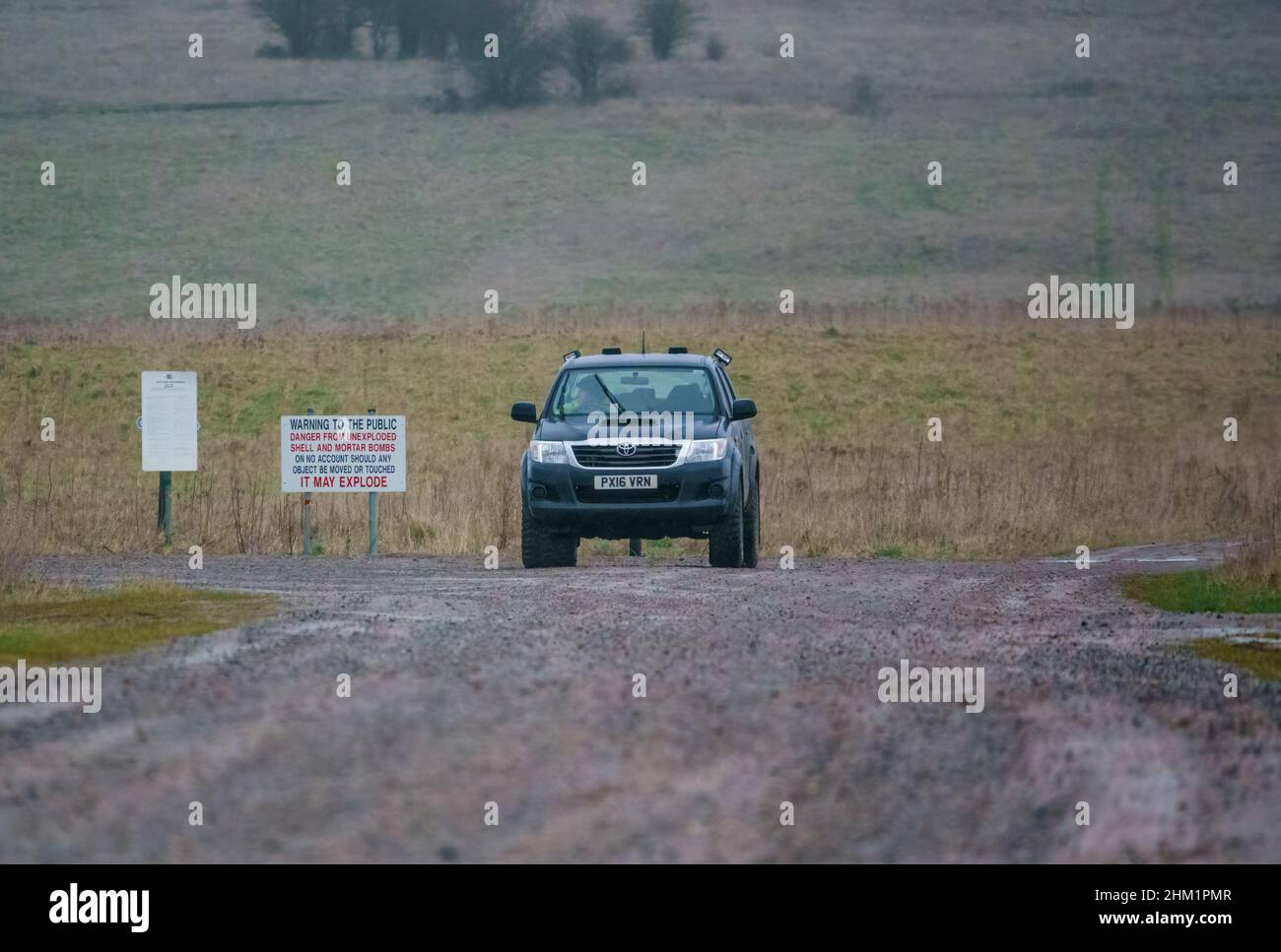 black toyota hilux SUV car driving along an unmade stone track road ...