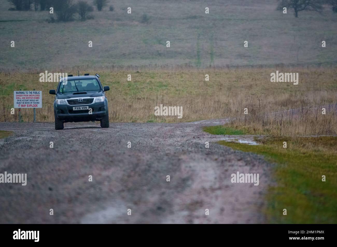 black toyota hilux SUV car driving along an unmade stone track road ...