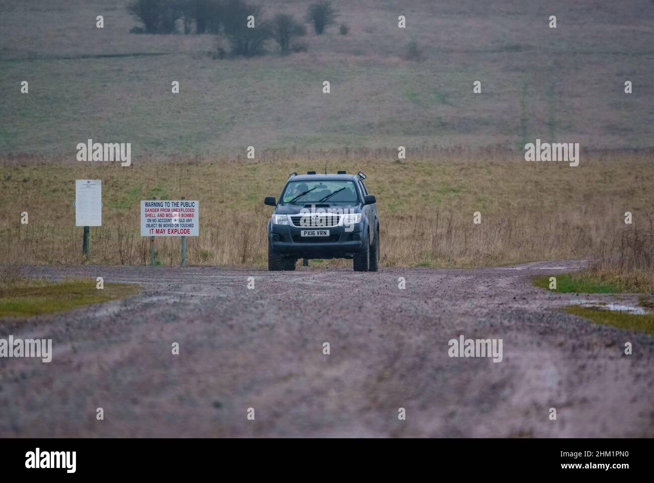 black toyota hilux SUV car driving along an unmade stone track road ...