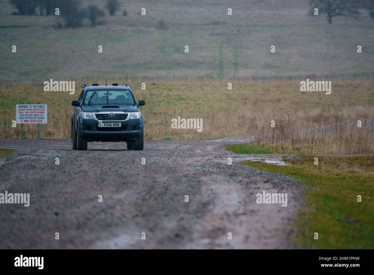 black toyota hilux SUV car driving along an unmade stone track road ...