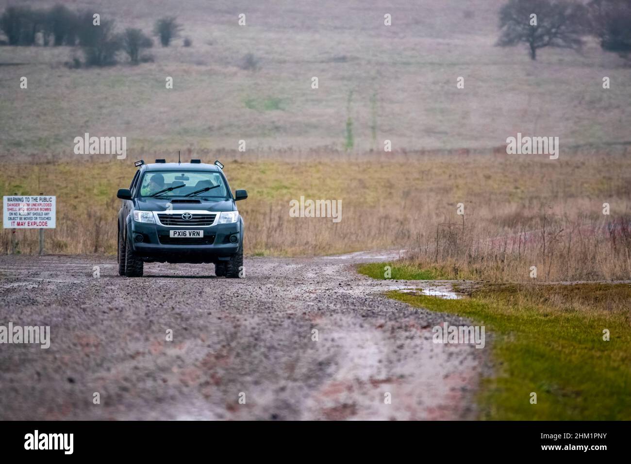 black toyota hilux SUV car driving along an unmade stone track road ...