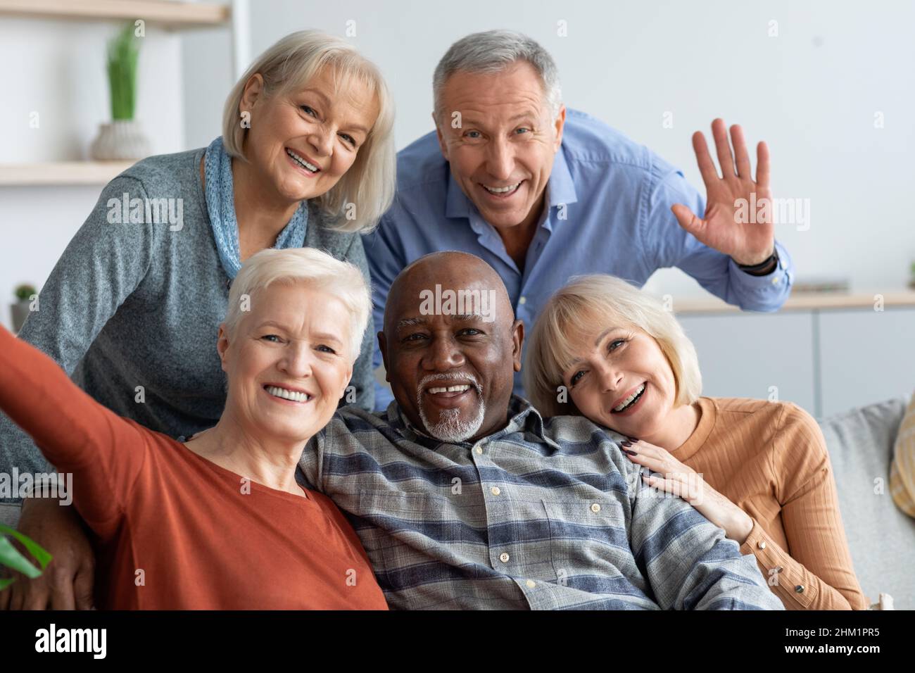 Happy elderly people taking selfie together, home interior Stock Photo ...