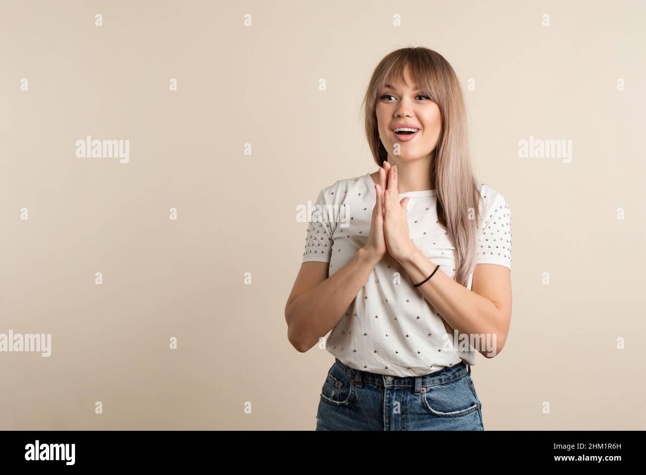 Ecstatic girl folded palms in gesture of thanks and is pleasantly ...