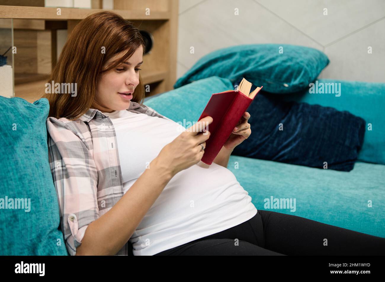 Beautiful redhead Caucasian woman in anticipation of a baby sitting on ...