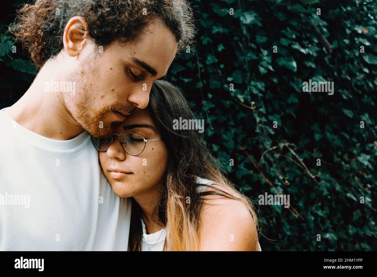 A young and natural spanish couple hugging each other in front of some ...
