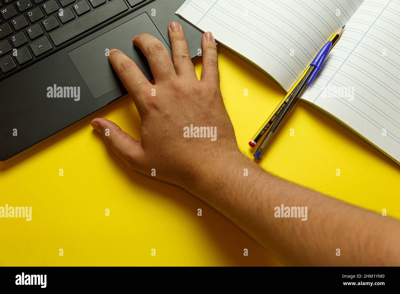Point of view of a young hand scrolling on the laptop while studying ...