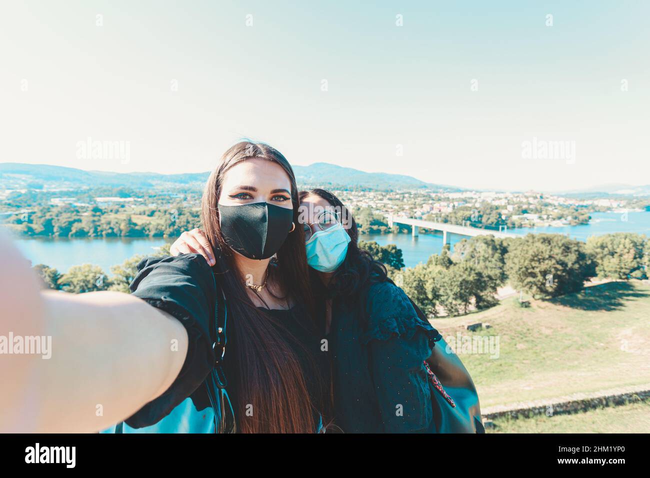 Two young girls taking a selfie with the masks on during a sunny day ...