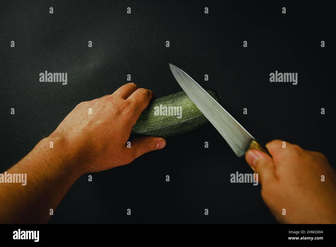 Cutting a cucumber with a long knife 2 Stock Photo - Alamy