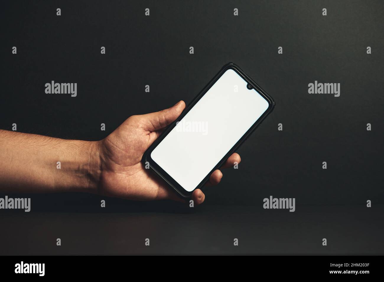 Hand holding a phone with a white screen Stock Photo - Alamy