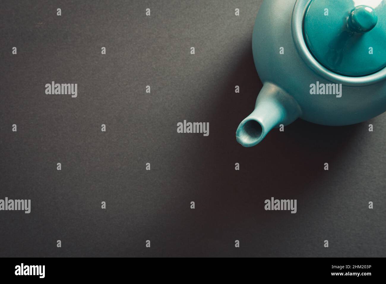 Top view of a blue vintage teapot showing from a corner over a dark background Stock Photo - Alamy