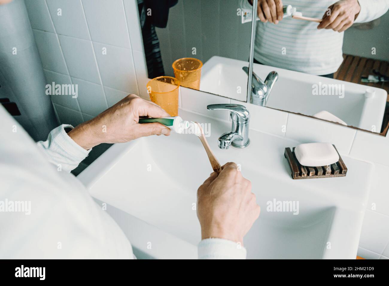 A woman puts teeth cream on his bamboo toothbrush Stock Photo - Alamy
